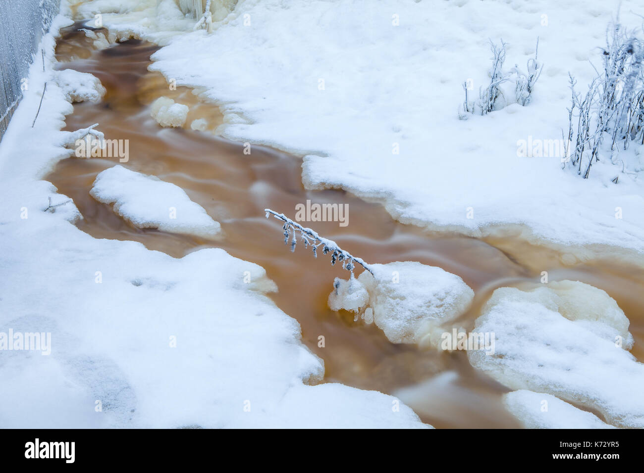 Winter creek covered by ice and snow. Typical northern swamp water ...