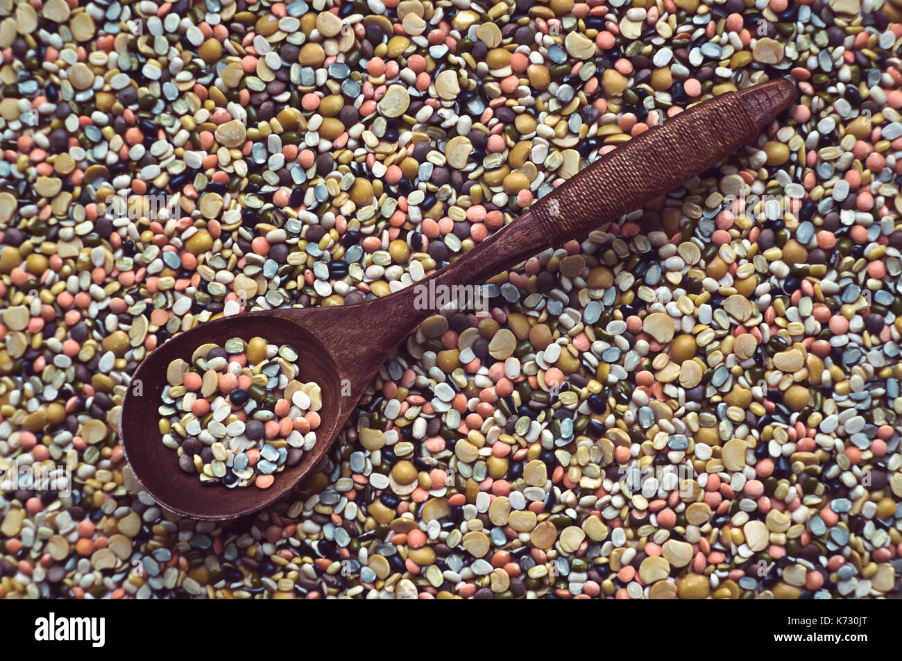 Various lentils mix in wooden spoon on the background of multi-colored ...