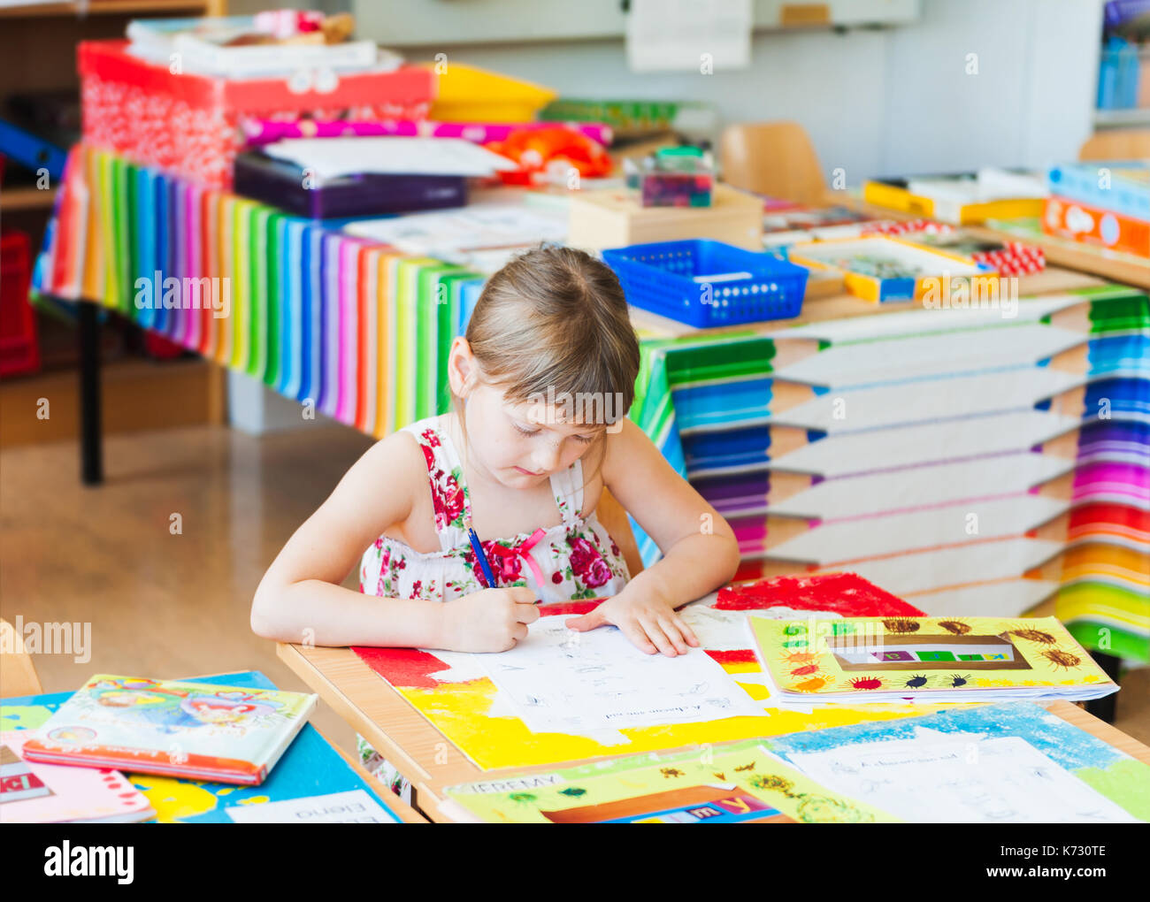 Cute little girl working in a classroom Stock Photo - Alamy