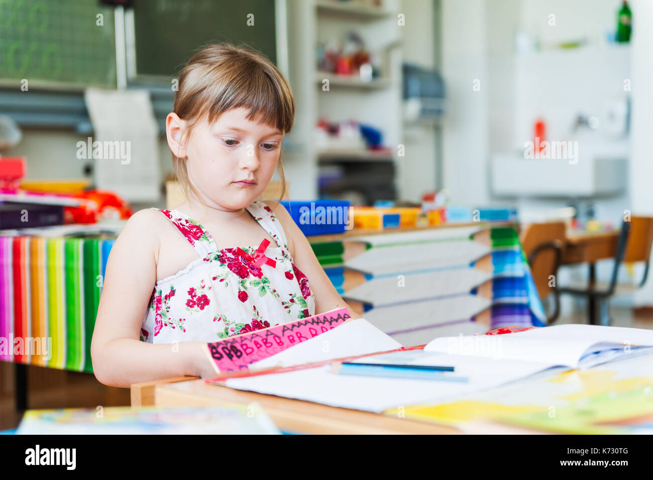 Cute little girl working in a classroom Stock Photo - Alamy