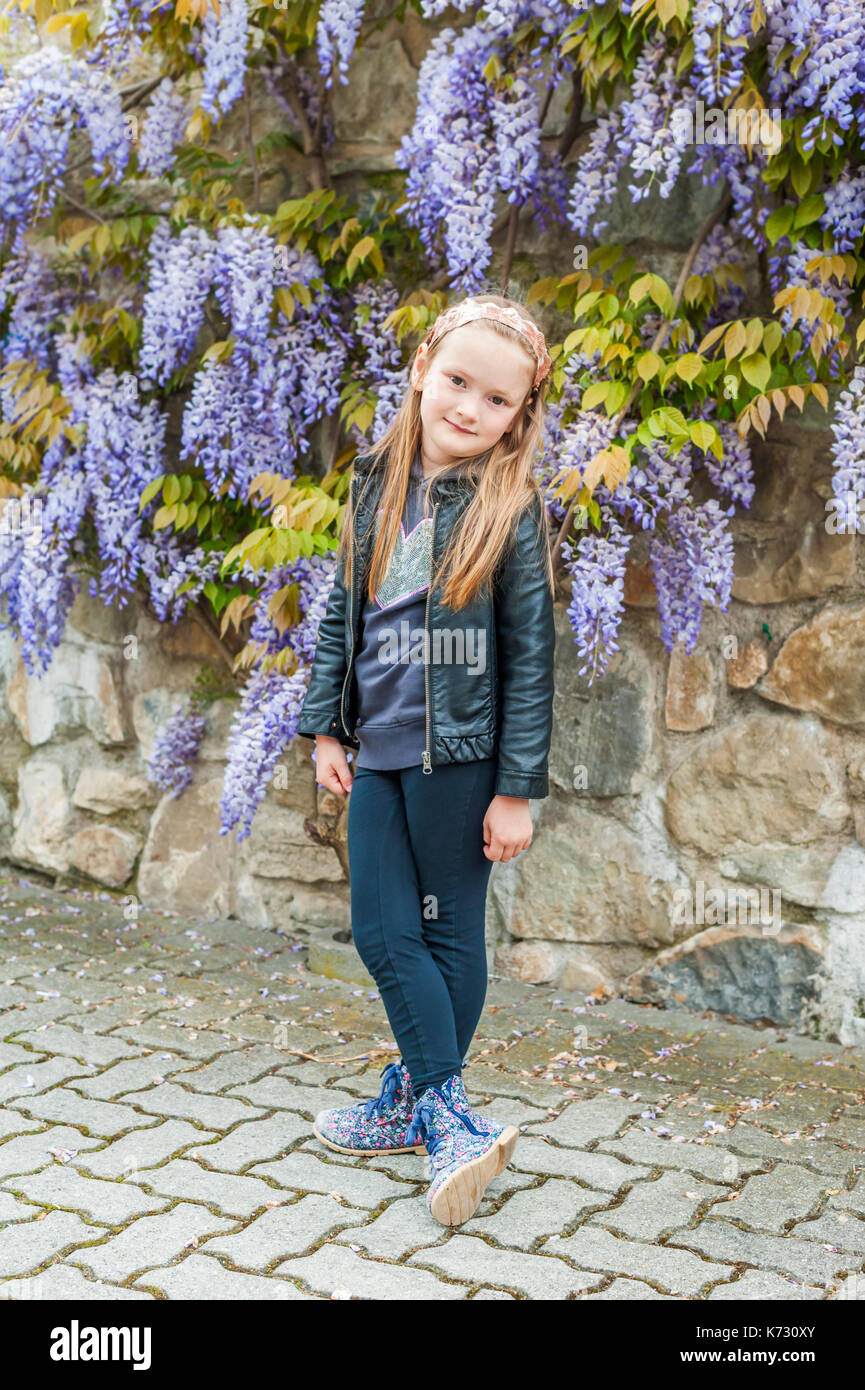 Spring portrait of cute kid girl with wisteria flowers on background ...