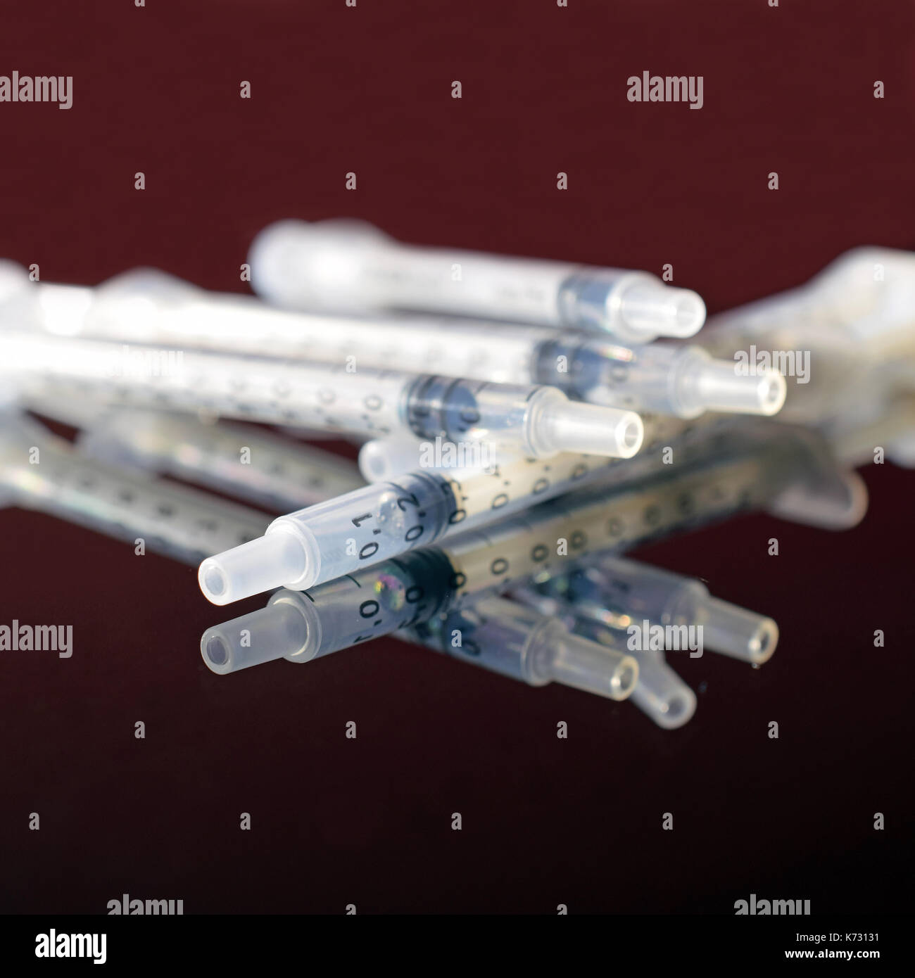 Pile of syringes on black reflective surface Stock Photo - Alamy