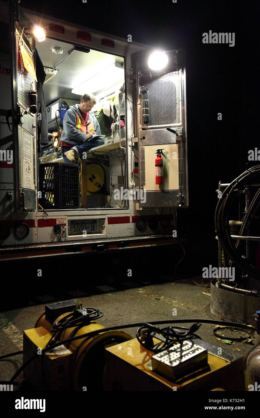 Public utility crews work during the night to restore power and other ...