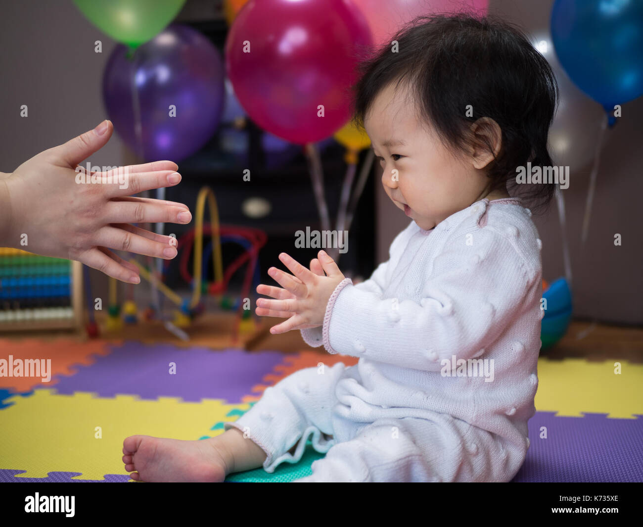 baby girl clapping with mom Stock Photo - Alamy