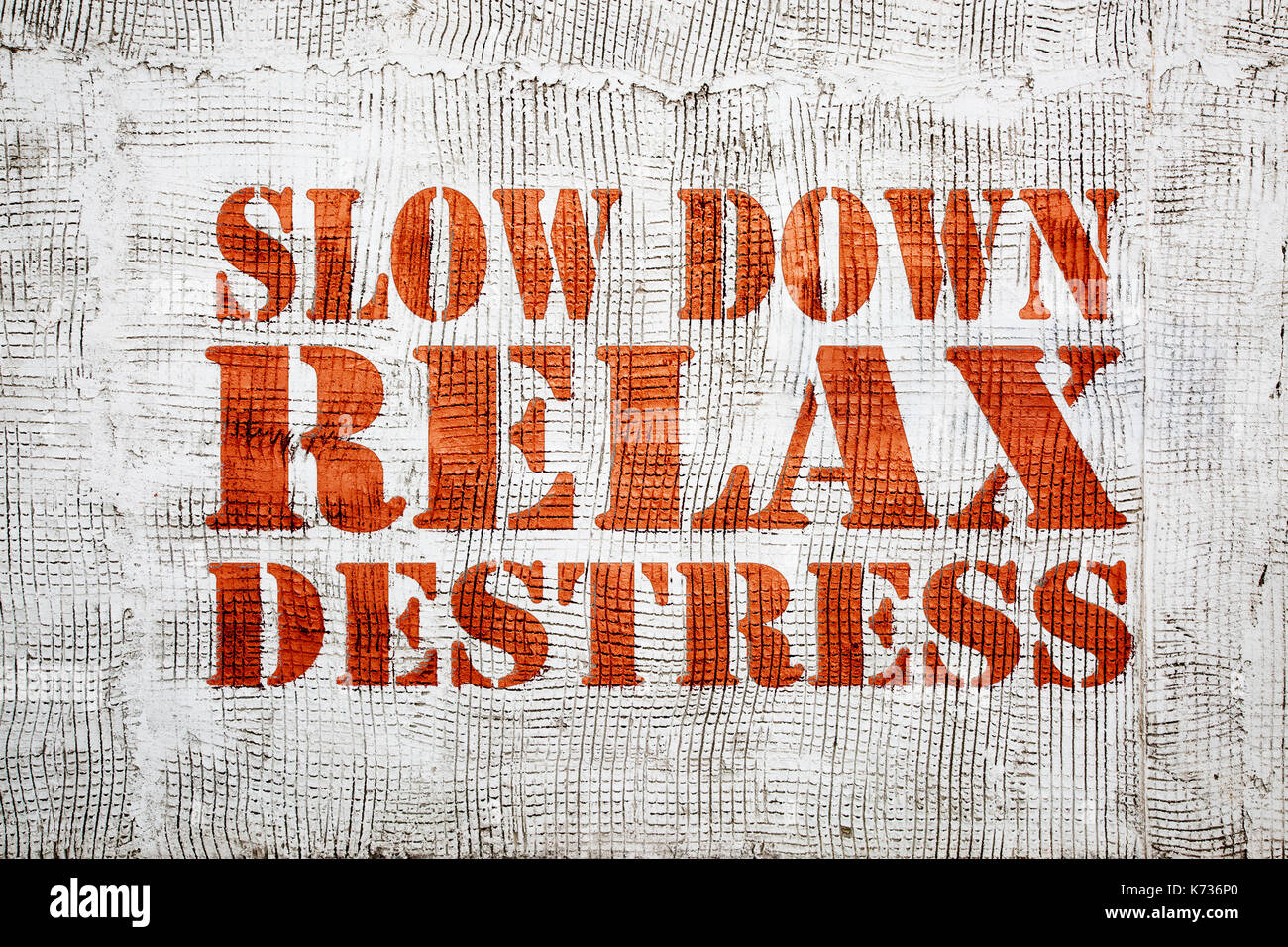 slow down, relax and destress - graffiti sign on a stucco wall Stock ...