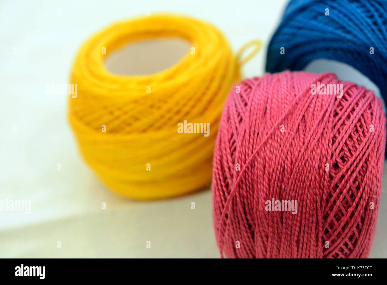 three colourful balls of embroidery thread Stock Photo - Alamy