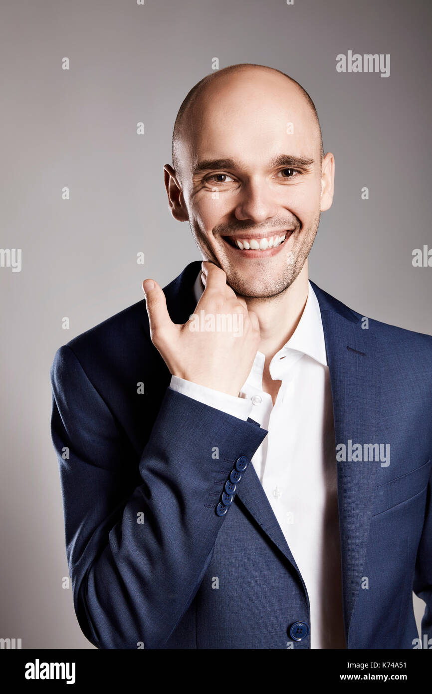 Portrait of handsome cheerful man stroking his chin Stock Photo - Alamy