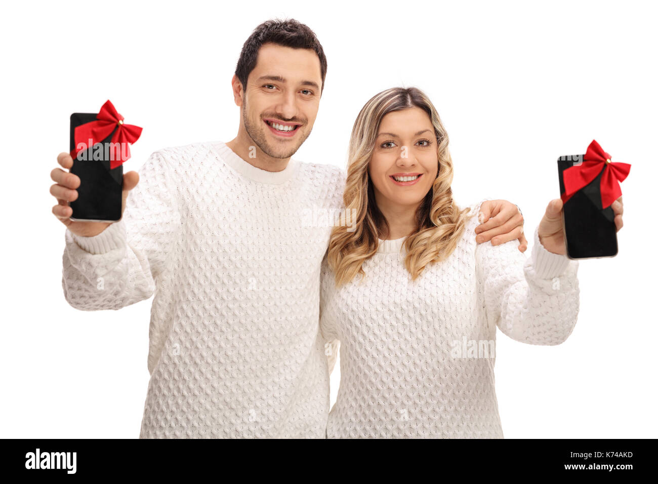 Young couple showing phones wrapped with red ribbons as gifts isolated ...