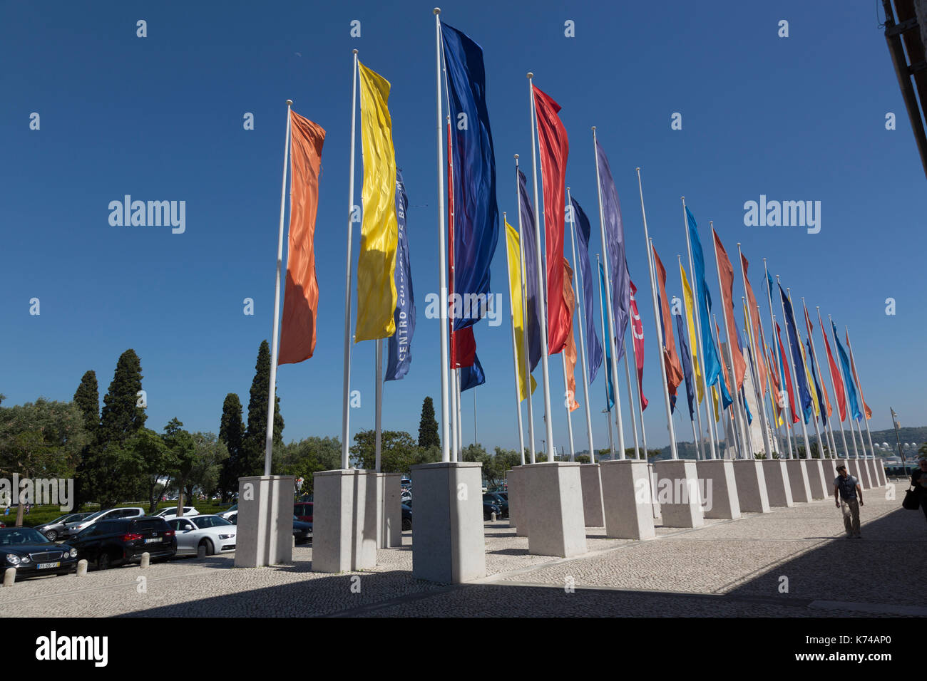 An array of brightly coloured flags flying from flag poles outside the ...