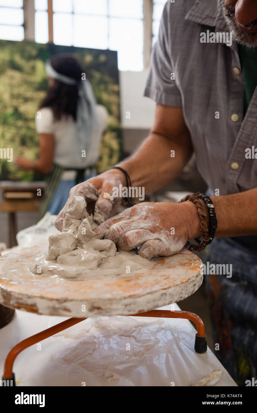Mid section of man molding clay in class Stock Photo - Alamy