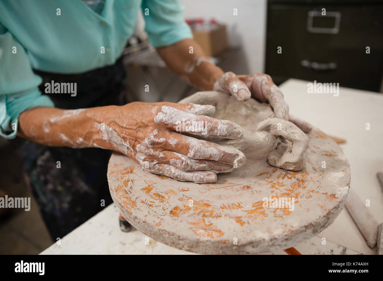 Mid section of man molding clay in class Stock Photo - Alamy