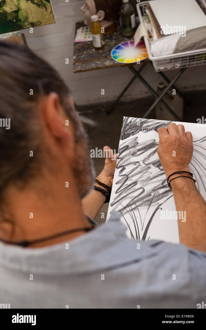 Rear view of man sketching in drawing book Stock Photo - Alamy