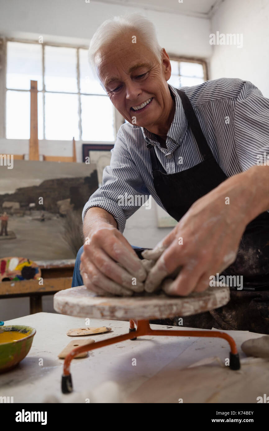 Smiling senior man molding clay in drawing class Stock Photo - Alamy