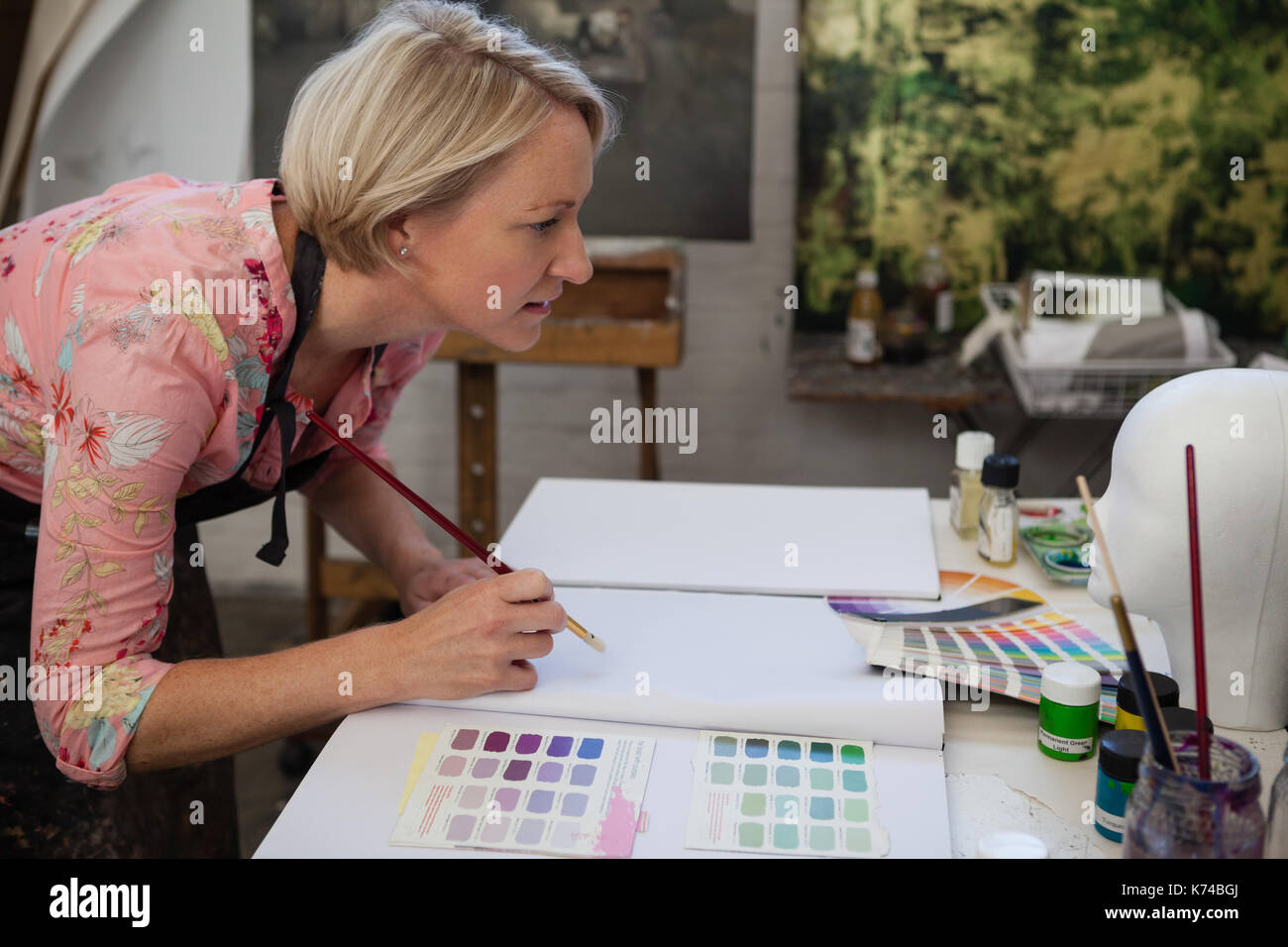 Woman painting in drawing book at drawing class Stock Photo - Alamy
