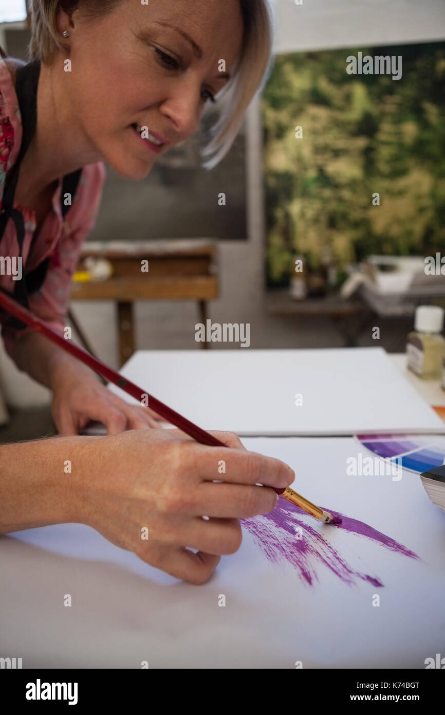 Woman painting in drawing book at drawing class Stock Photo - Alamy