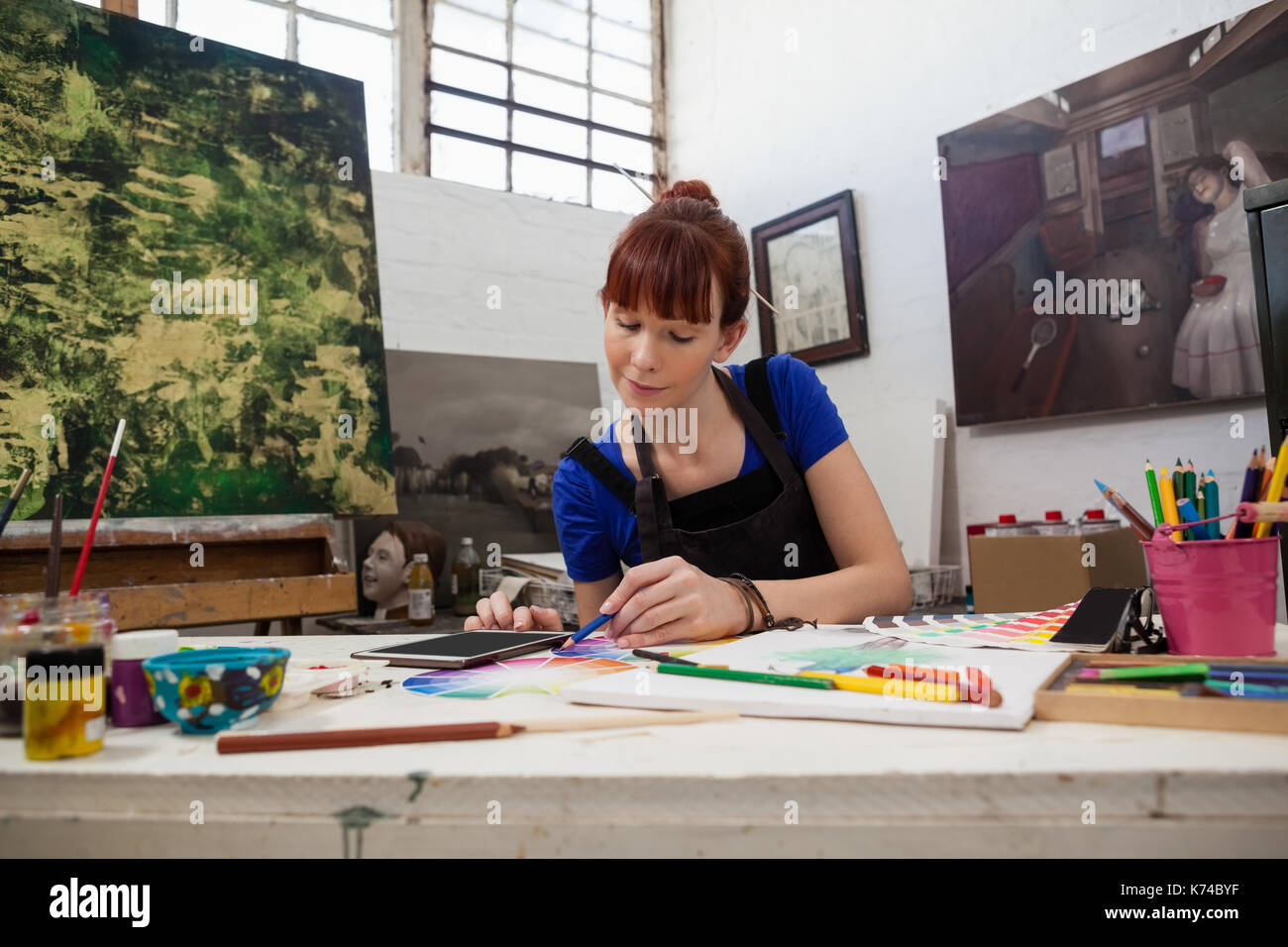 Beautiful woman matching color with color swatch at table Stock Photo ...