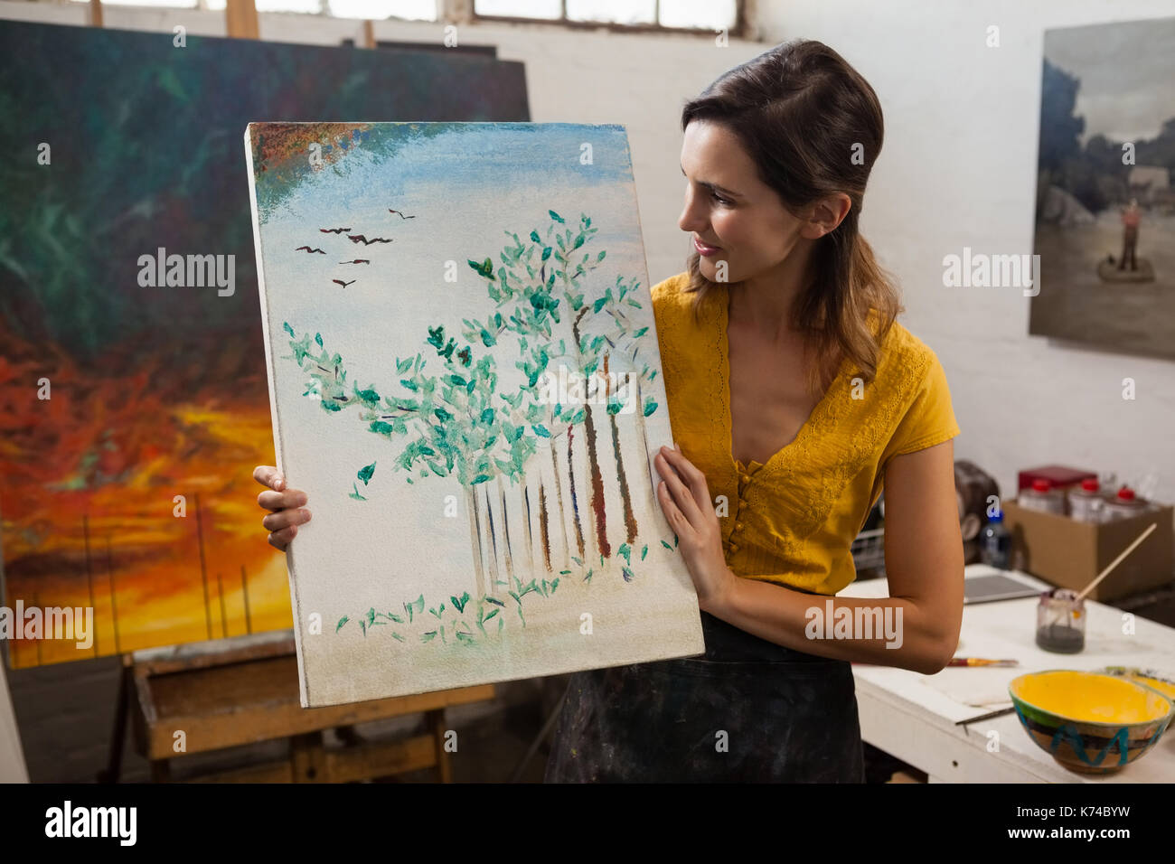 Woman holding a painting in drawing class Stock Photo - Alamy