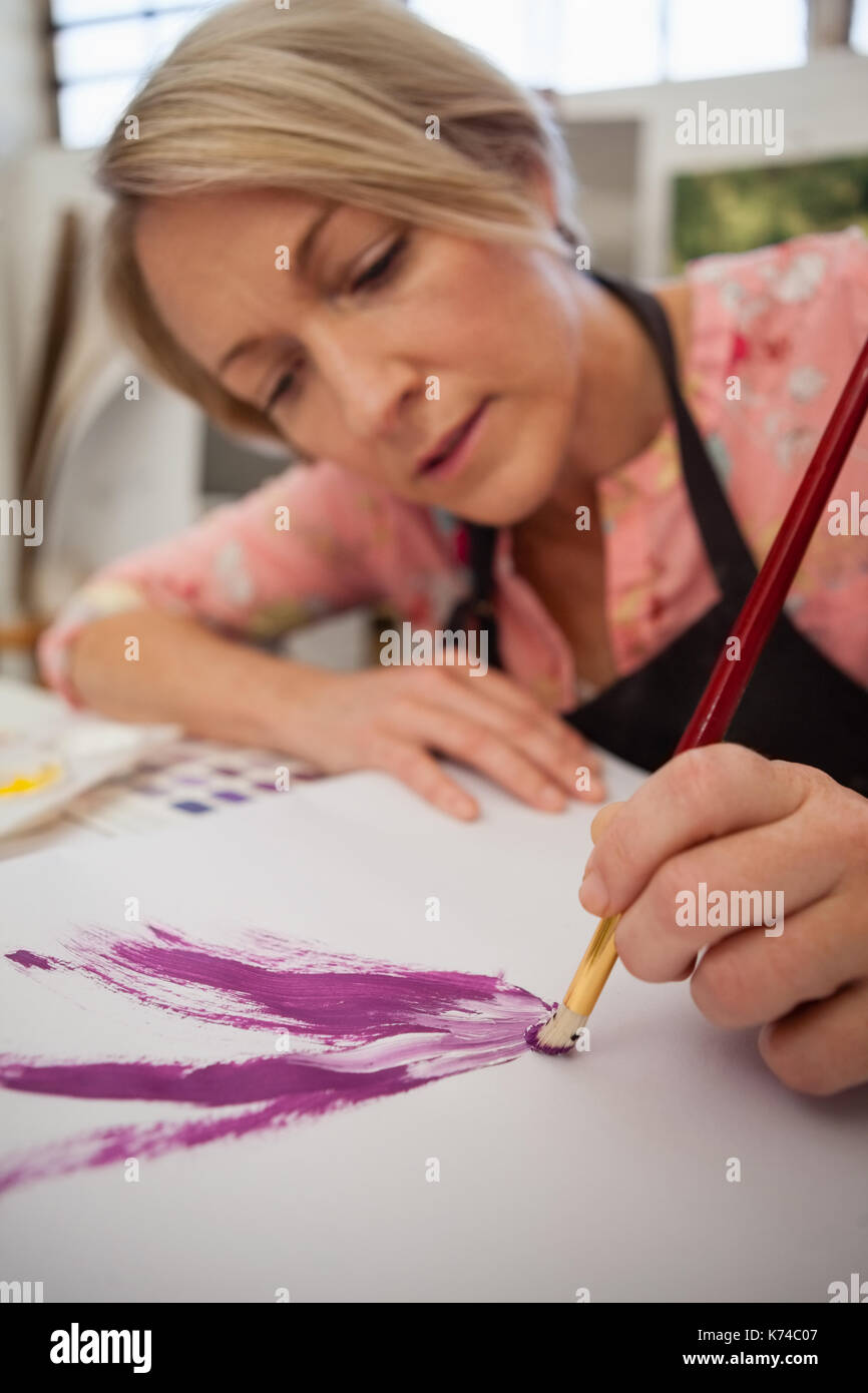 Woman painting in drawing book at drawing class Stock Photo - Alamy