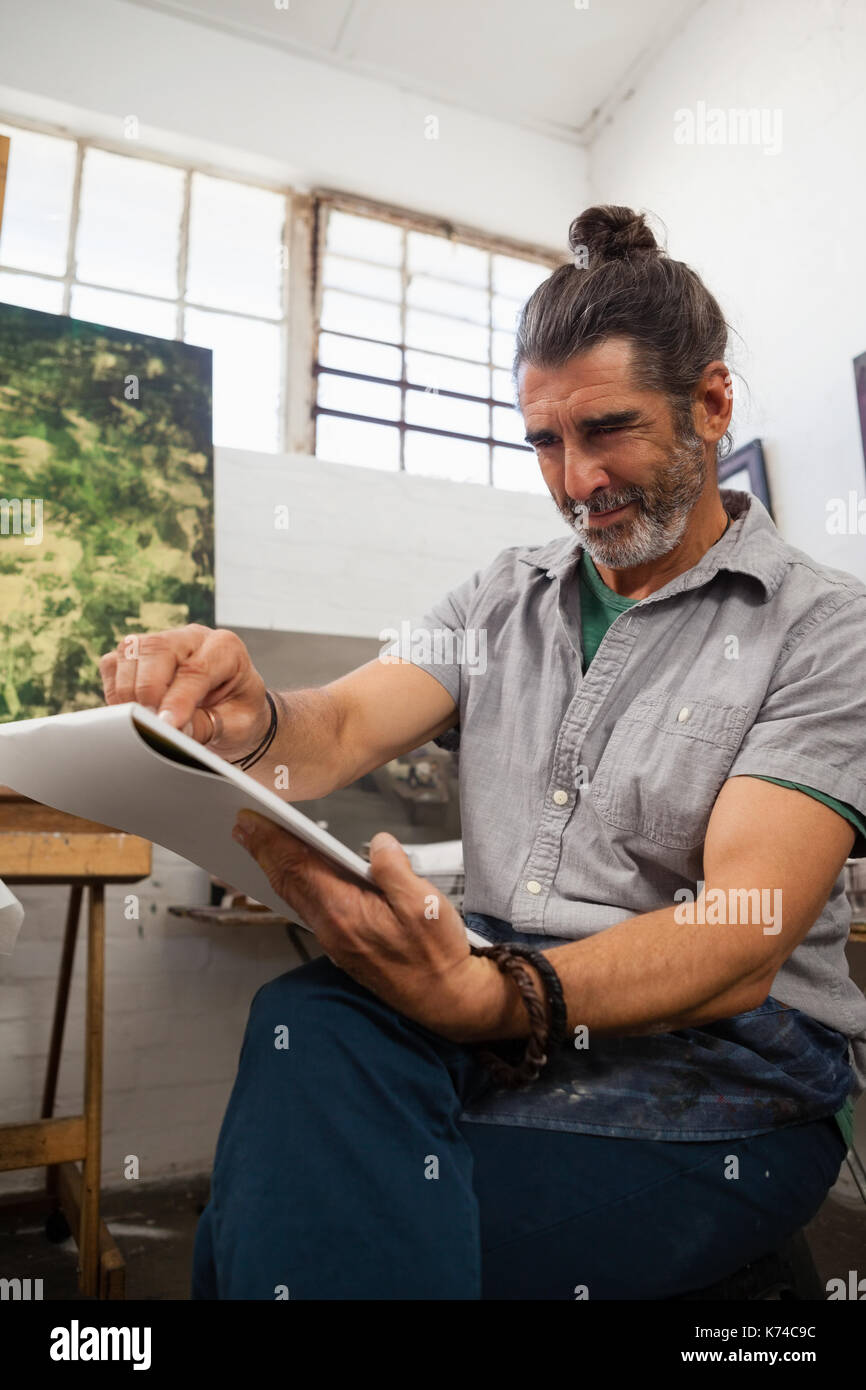 Attentive man painting in drawing book Stock Photo - Alamy