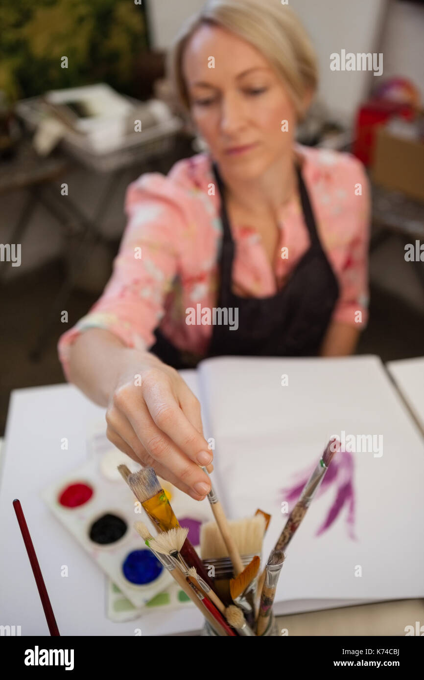 Woman painting in drawing book at drawing class Stock Photo - Alamy