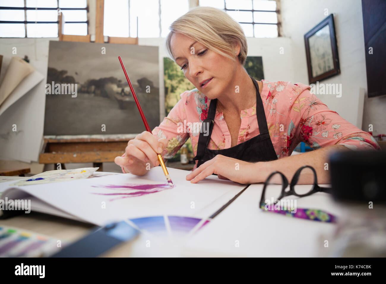 Woman painting in drawing book at drawing class Stock Photo - Alamy