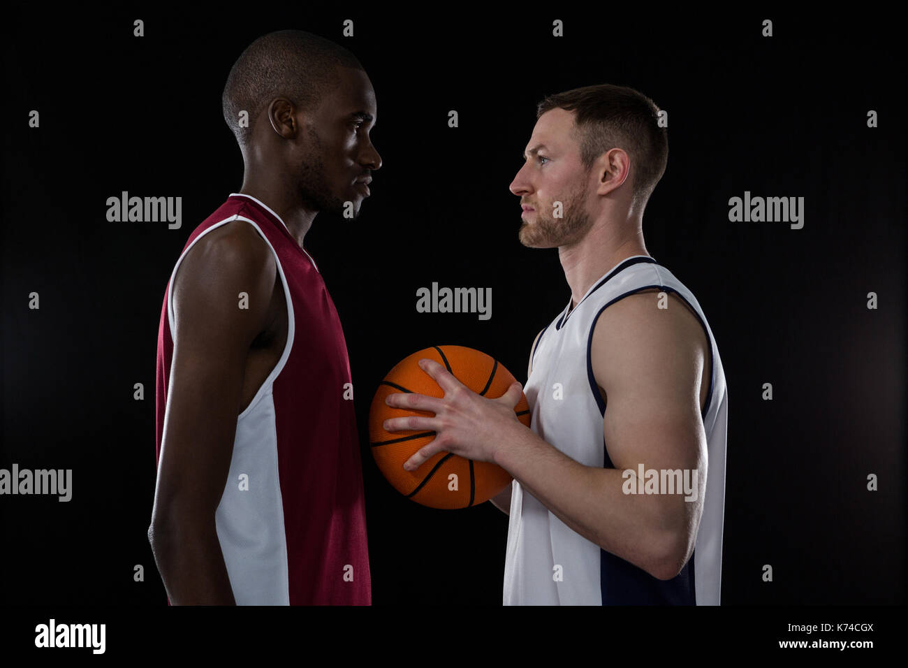 Competitors standing face to face against black background Stock Photo ...