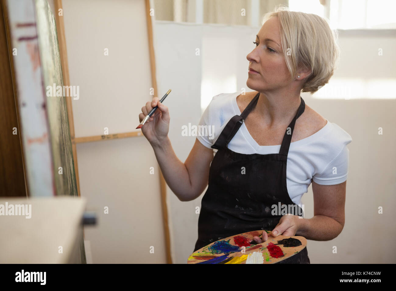 Woman painting on canvas in drawing class Stock Photo - Alamy