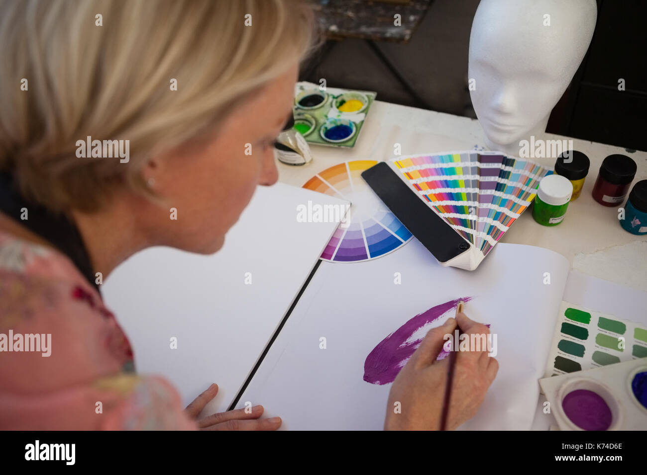 Woman painting in drawing book at drawing class Stock Photo - Alamy