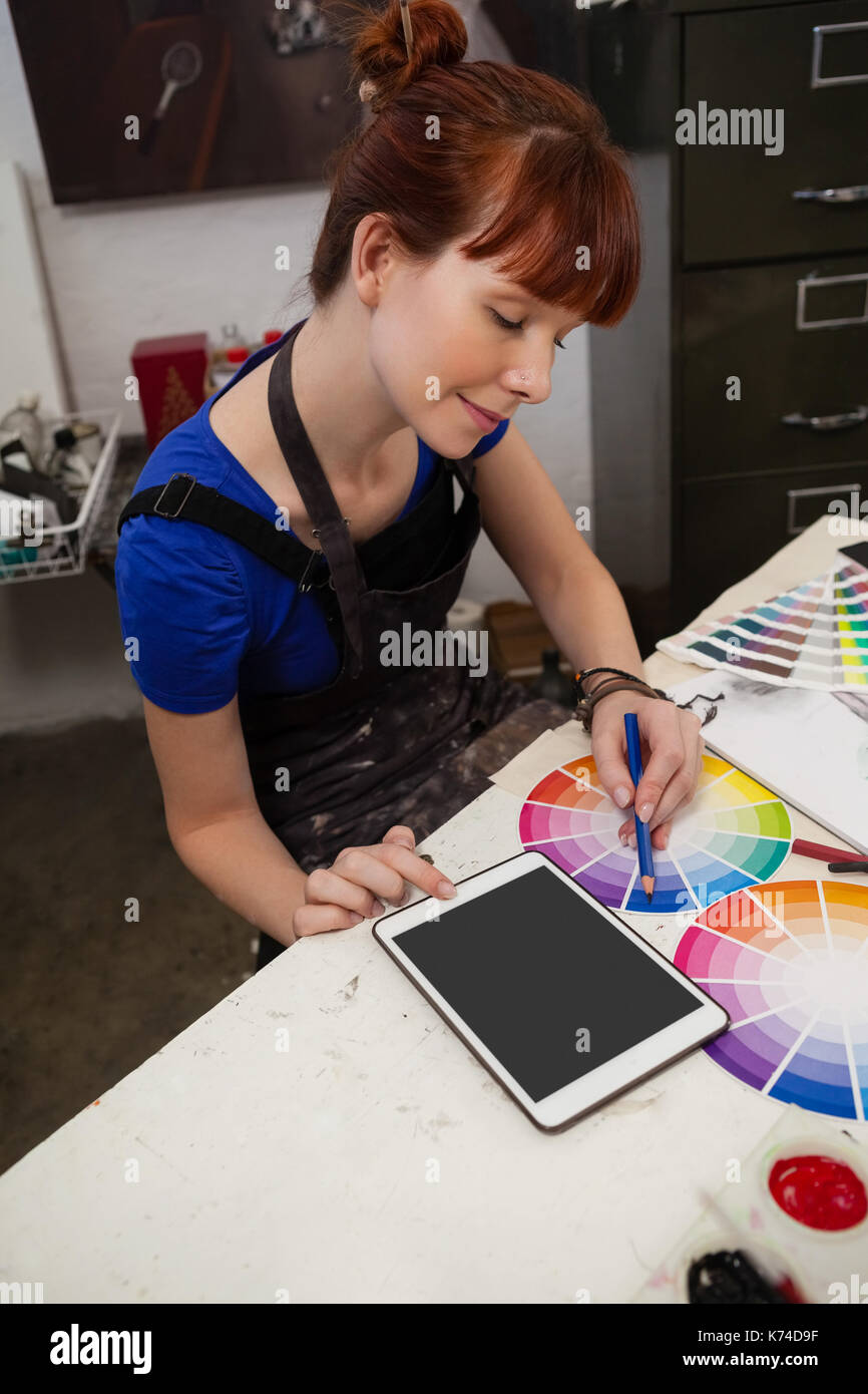 Beautiful woman matching color with color swatch at table Stock Photo ...