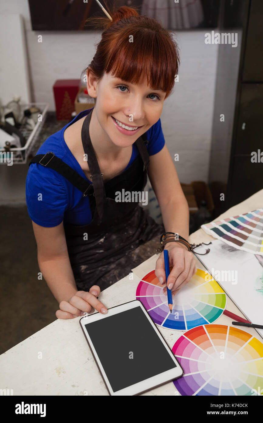 Portrait of beautiful woman matching color with color swatch at table ...