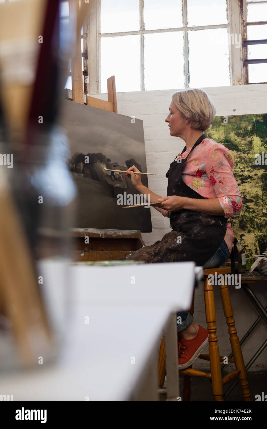 Woman painting on canvas in drawing class Stock Photo - Alamy