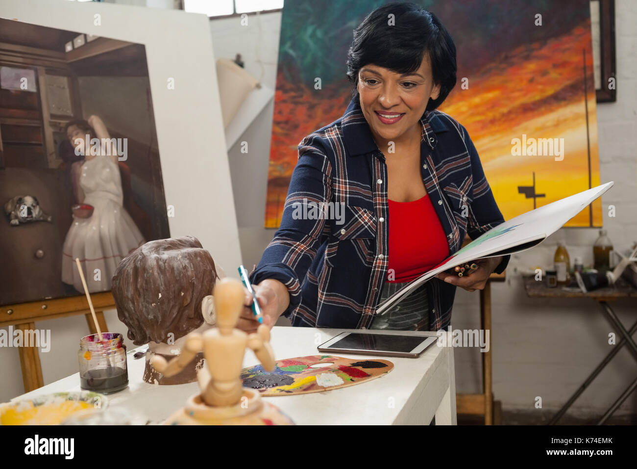 Woman painting in drawing book at drawing class Stock Photo - Alamy