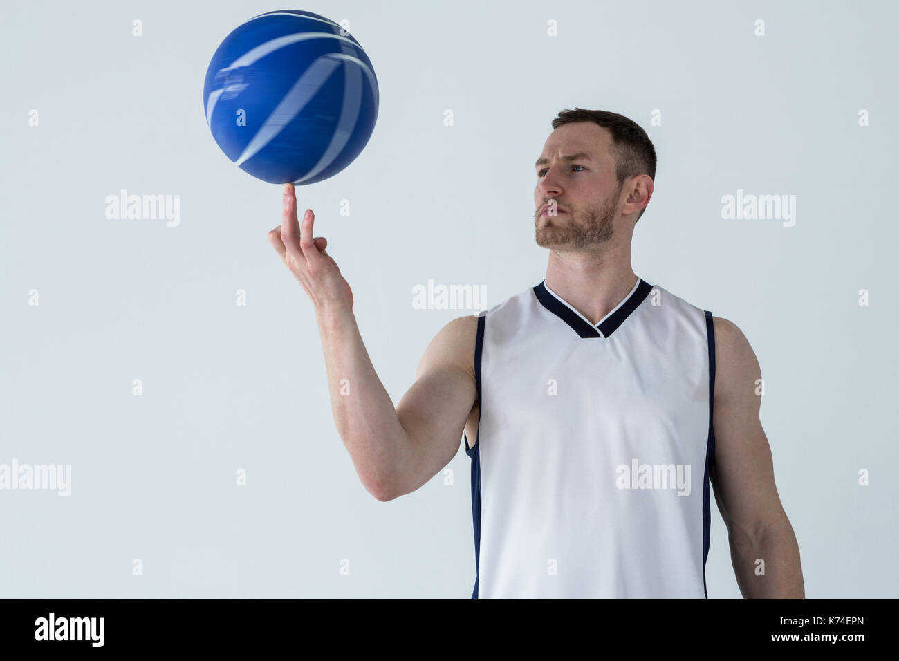 Player spinning basketball on finger against white background Stock ...