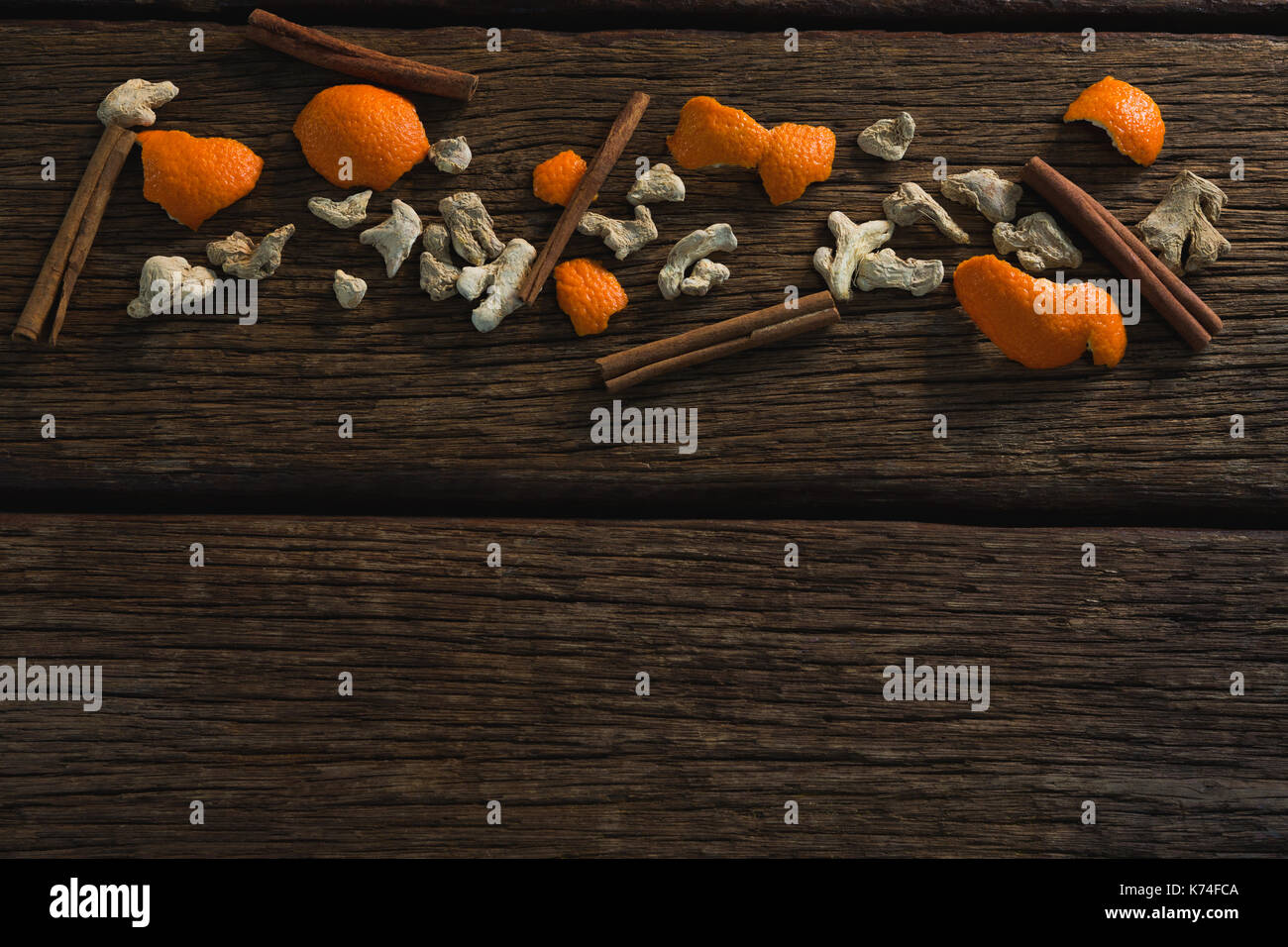 Overhead view of cinnamon sticks, orange peel and dried ginger on a ...