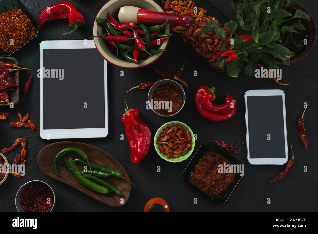 Overhead of various spices with digital tablet and mobile phone on ...