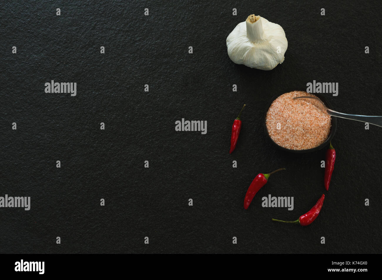 Close-up of garlic, red chili pepper and salt on black background Stock ...