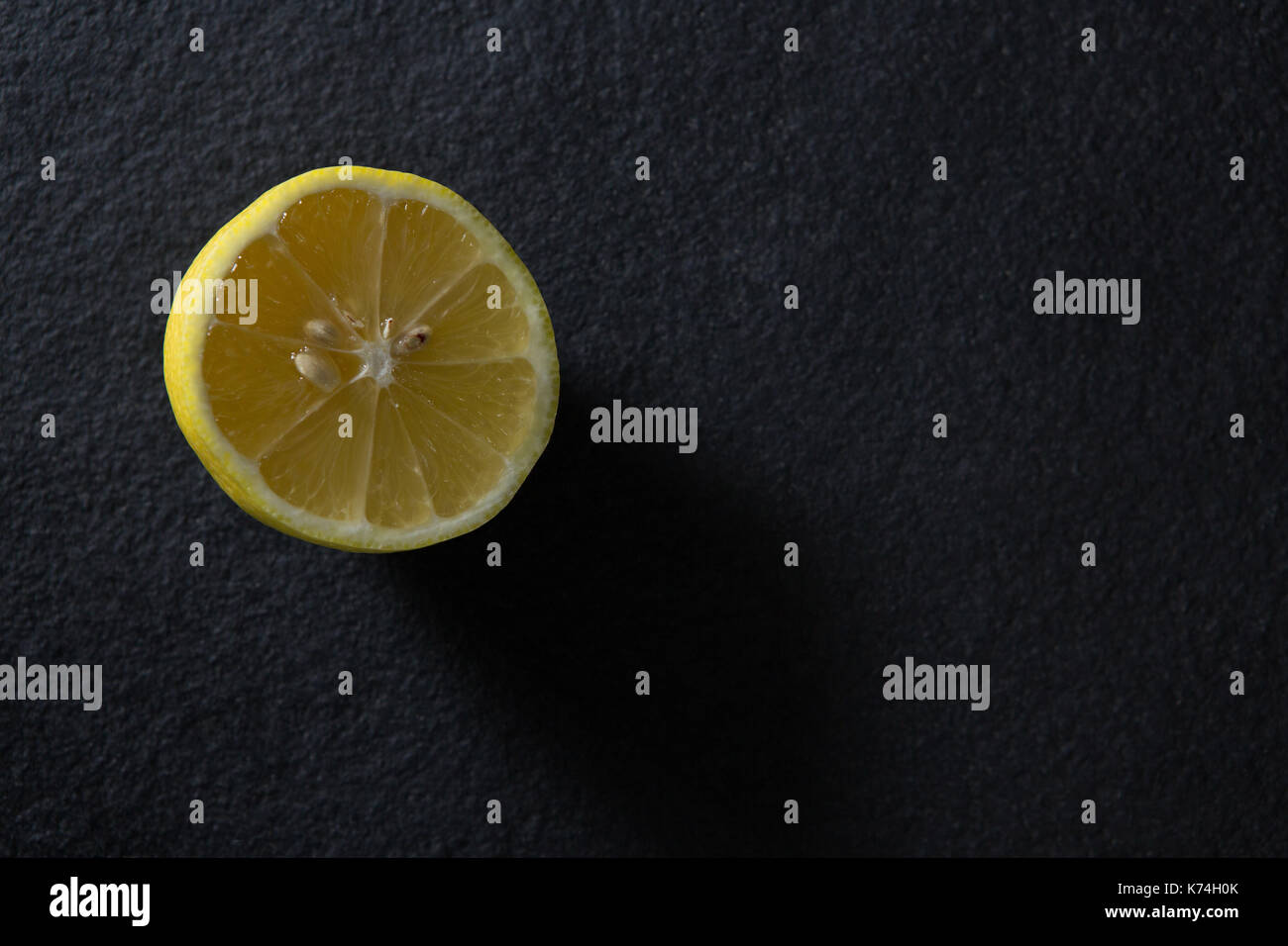 Overhead of halved lemon on black background Stock Photo - Alamy
