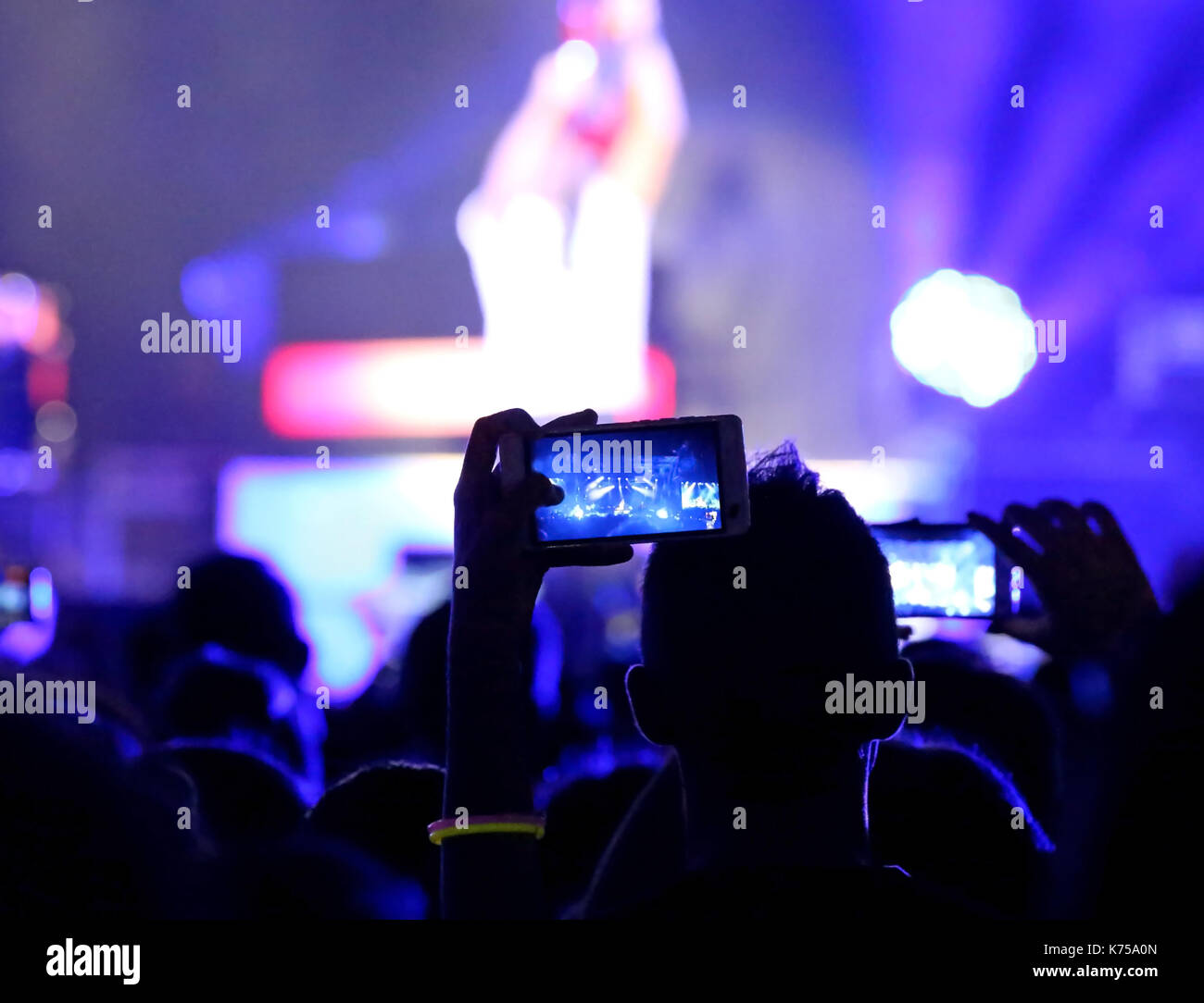 fans who take photos and record videos with modern smartphones during ...