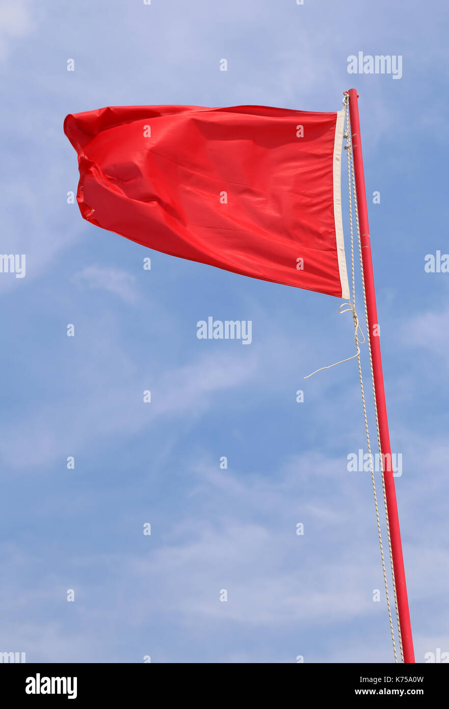red waving flag indicating a state of danger and alarm with background ...