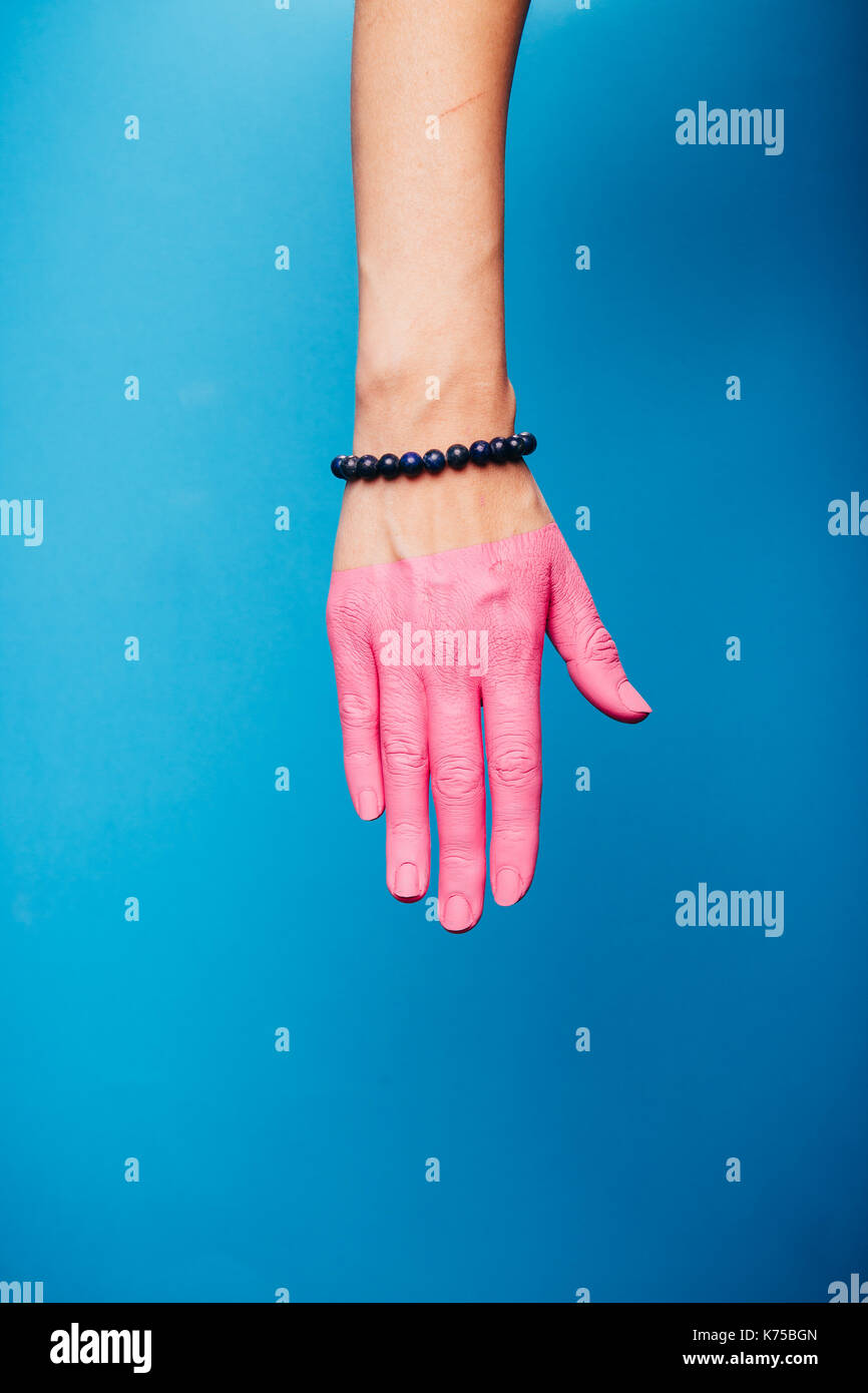 one woman hand, Caucasian painted rose pink hand skin, blue background ...