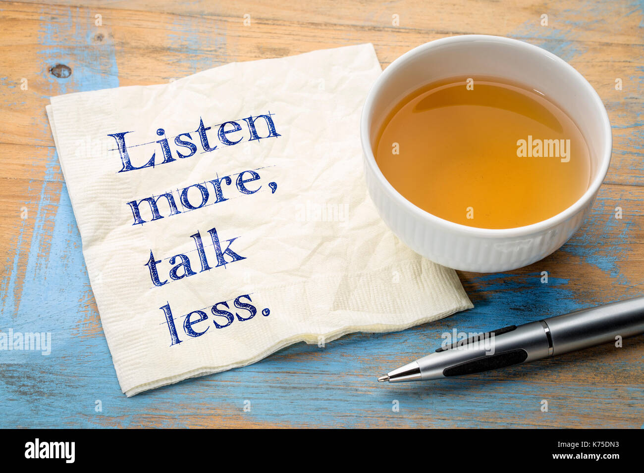 Listen more, talk less - motivational text on a napkin with a cup of ...