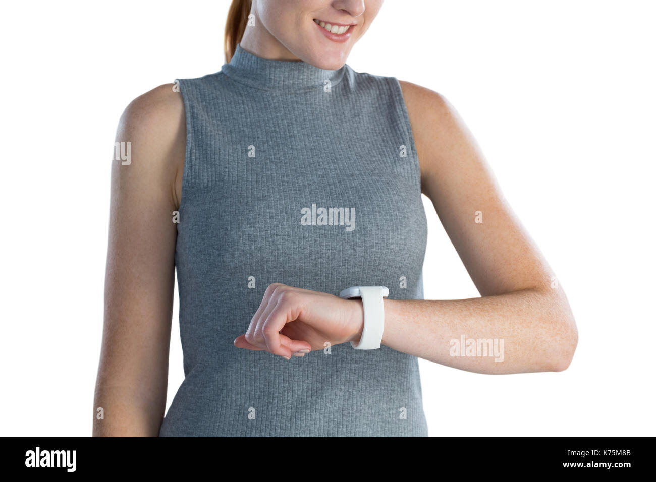 Mid section of businesswoman looking at wrist watch while standing ...