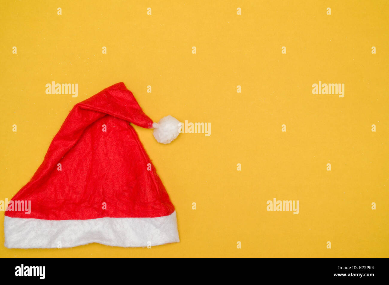 Christmas theme texture with Santa hat and yellow background. With copy ...