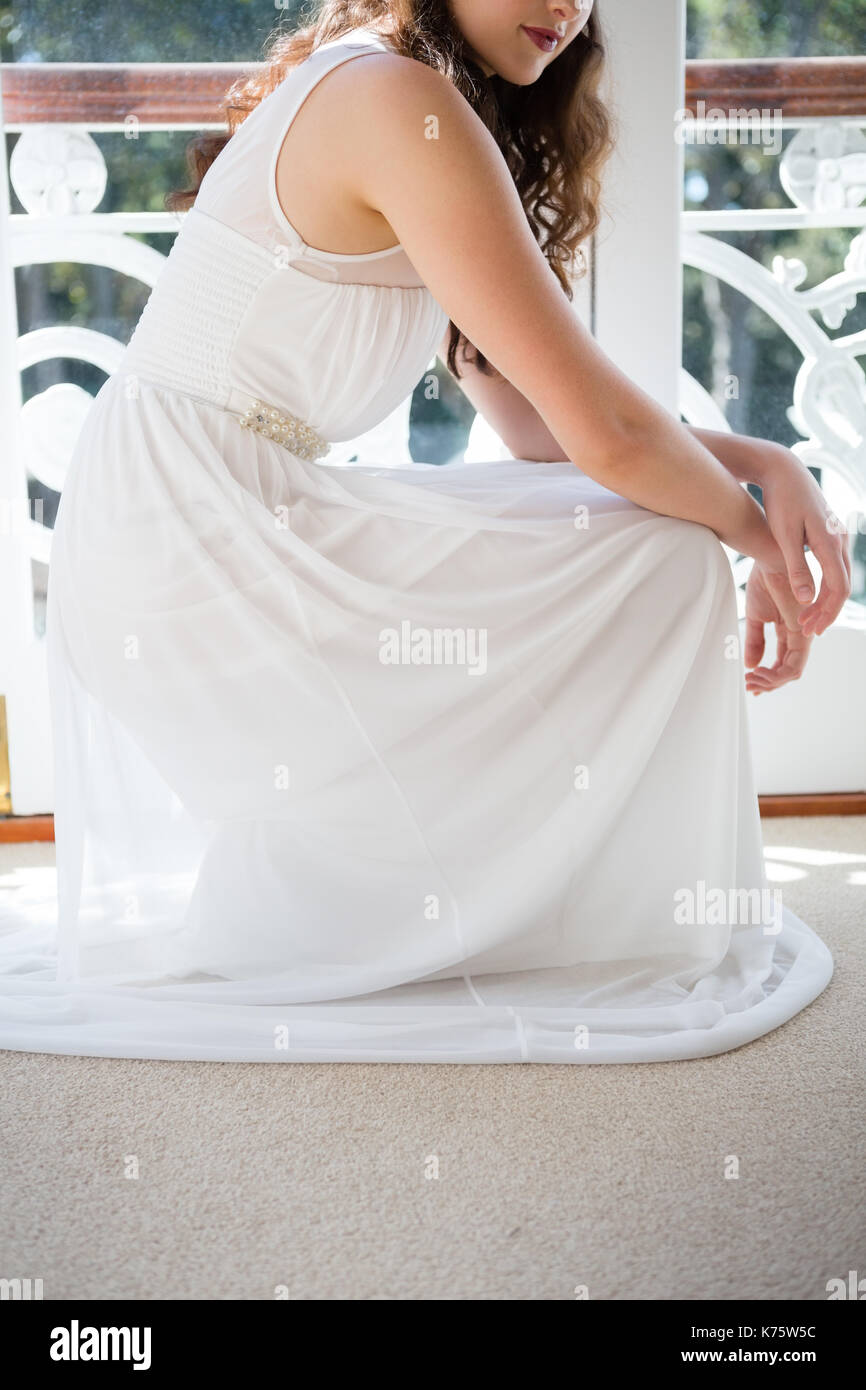 Low section of beautiful bride crouching by door at home Stock Photo ...