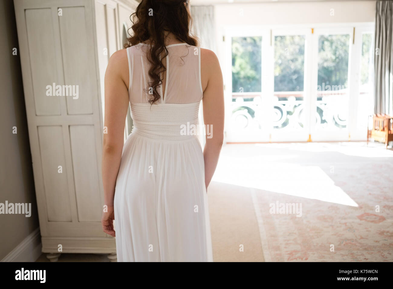 Rear view of bride in wedding gown standing at home Stock Photo - Alamy