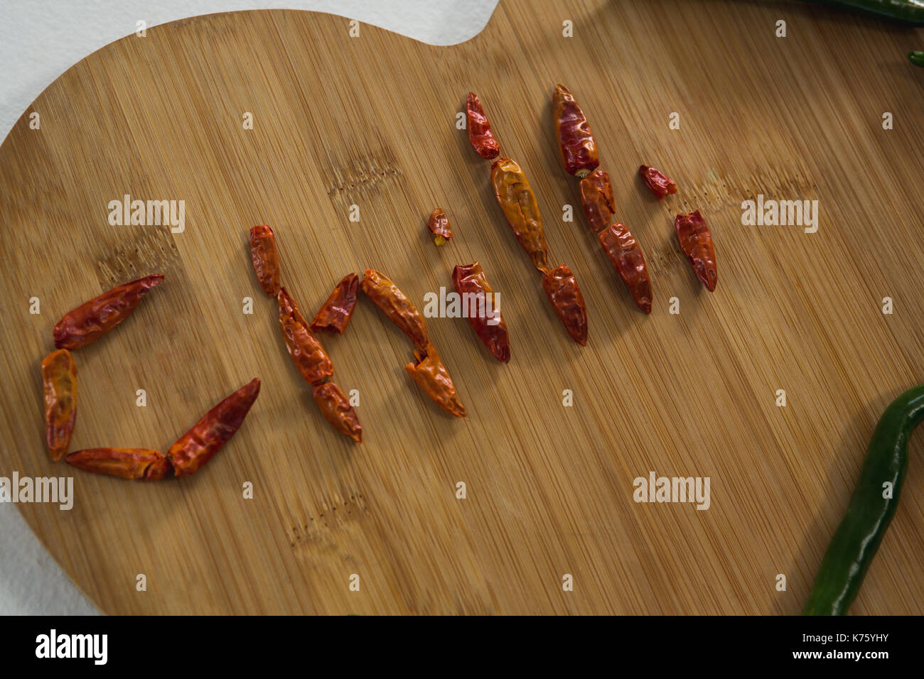 Dried red chili pepper arranged in chili text with green chili on heart ...