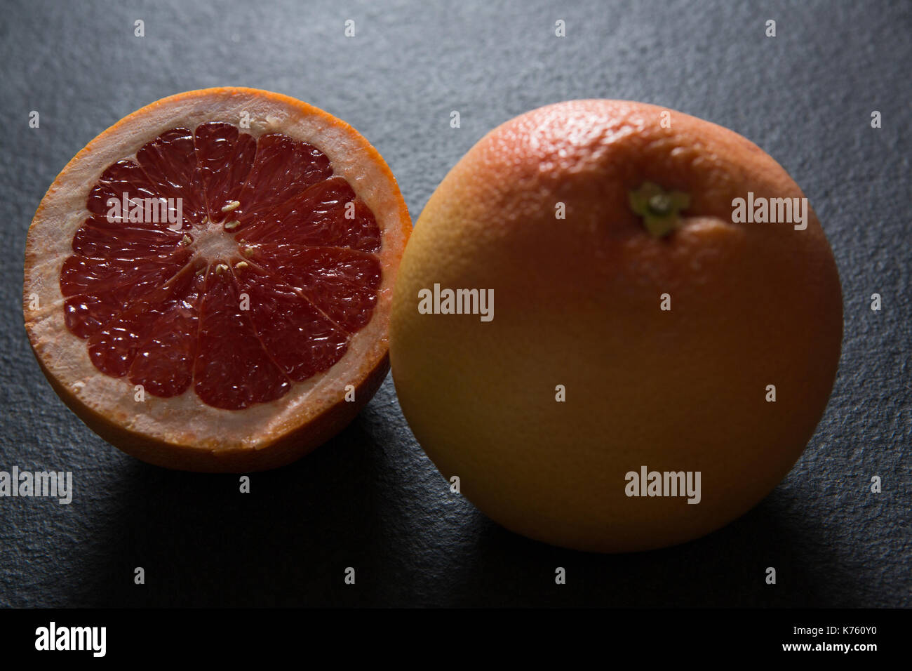 Close-up of grapefruit with half grapefruit on black background Stock ...