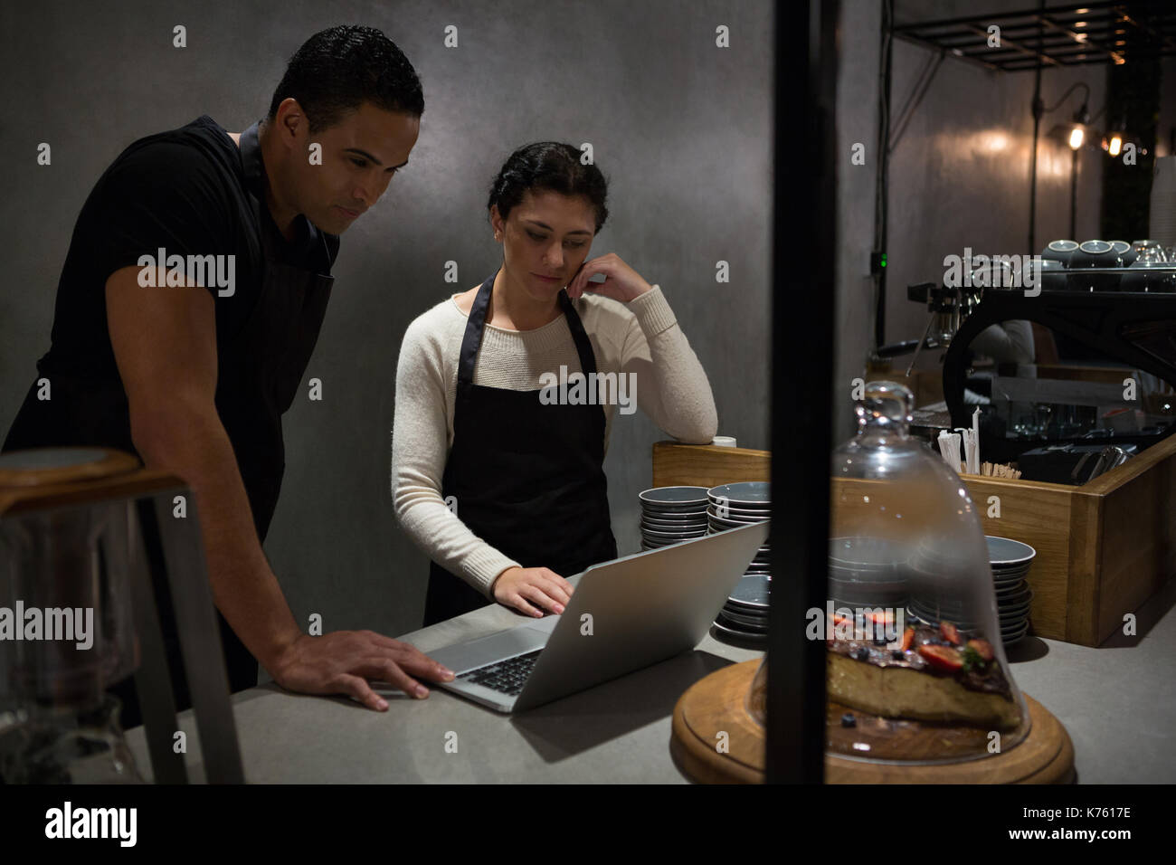 Waiter and waitresses using laptop at counter in restaurant Stock Photo ...
