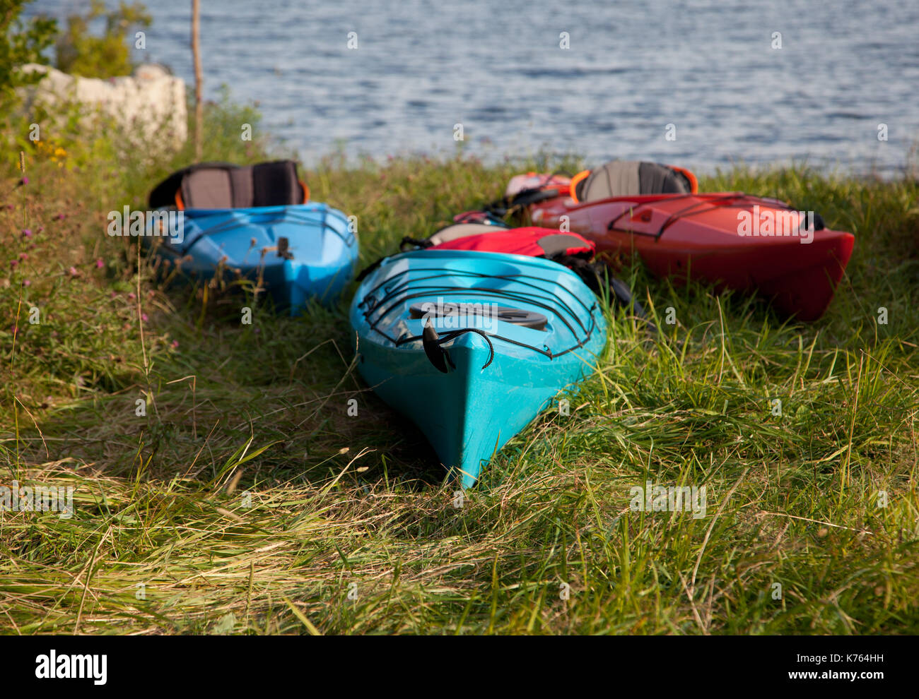 three colorful kayaks ready for a paddle or adventure by the shoreline ...