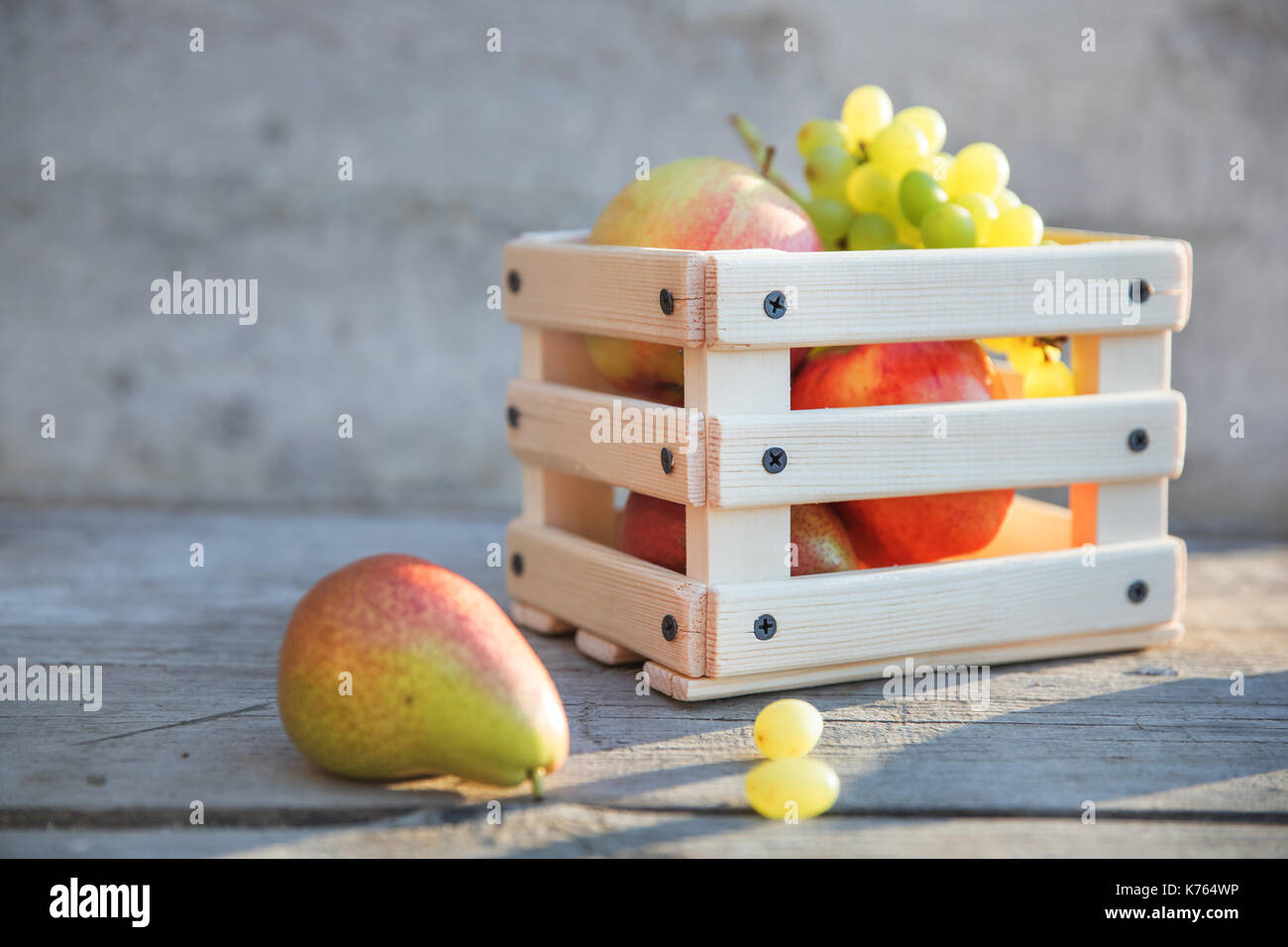 Grapes, pear and apple fruits in a box on wooden background Stock Photo ...
